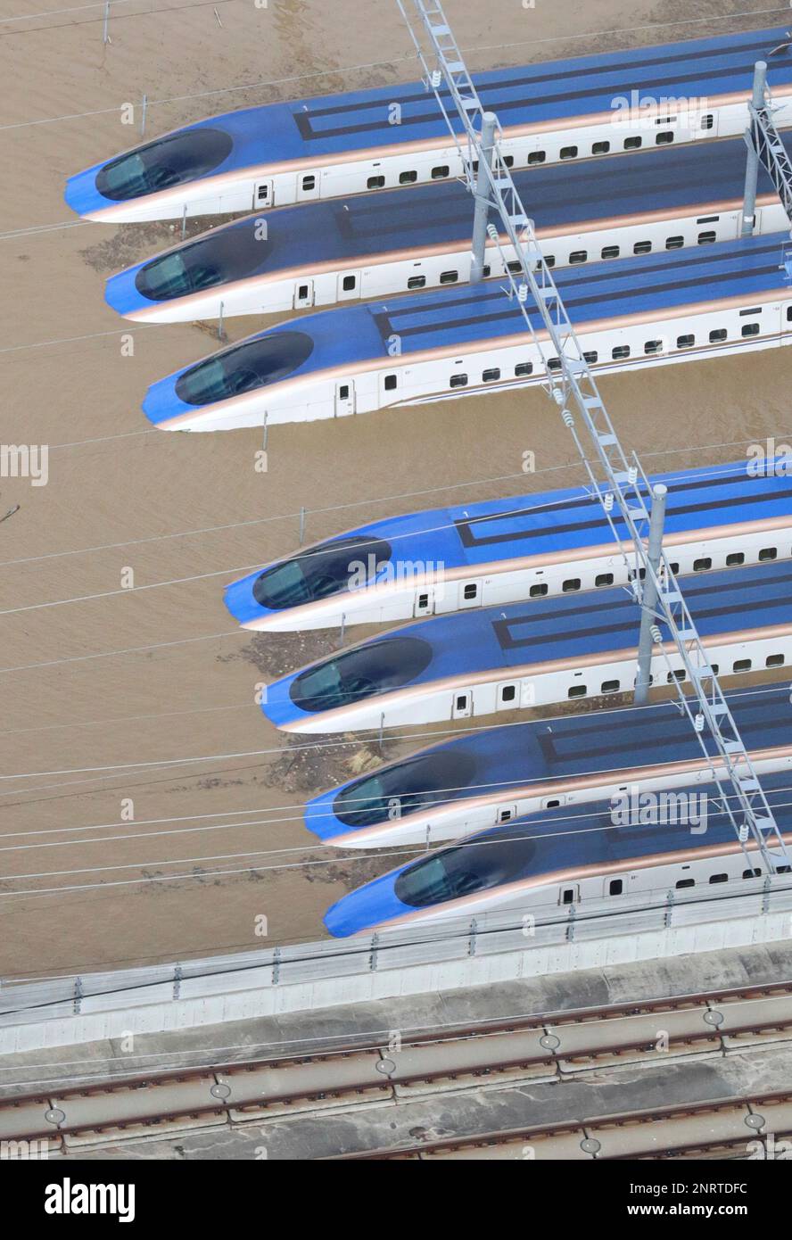 An aerial photo shows Shinkansen bullet trains covered with water as ...