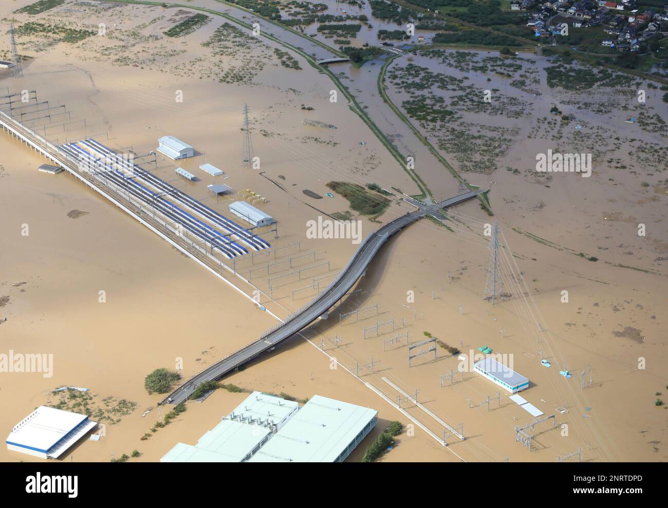 An aerial photo shows Shinkansen bullet trains covered with water as ...