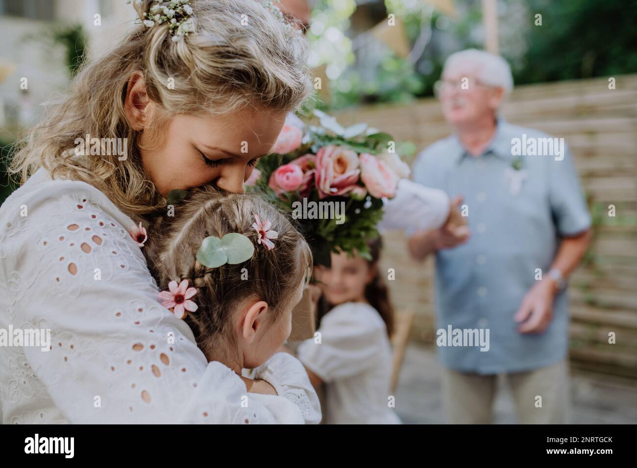 Bride receiving congratulations by little girls at outdoor wedding ...