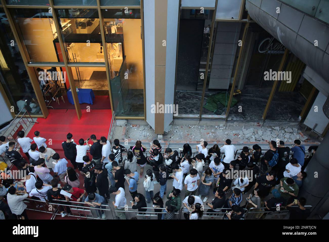 Fans queue up outside a department store to buy the latest model of ...