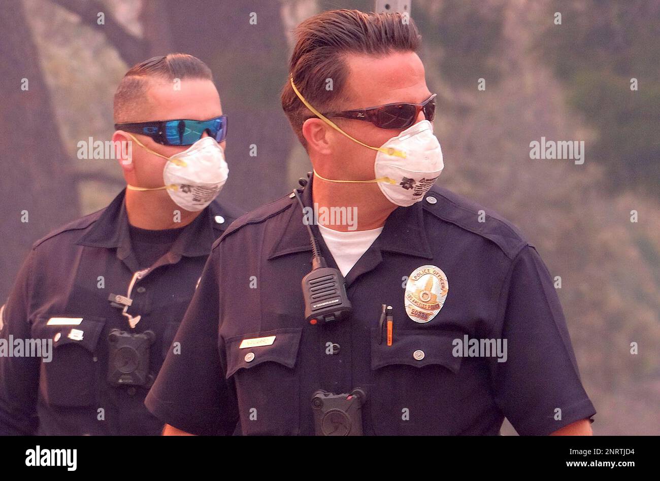 LAPD officers wear masks to help protect against the smoke as they work ...