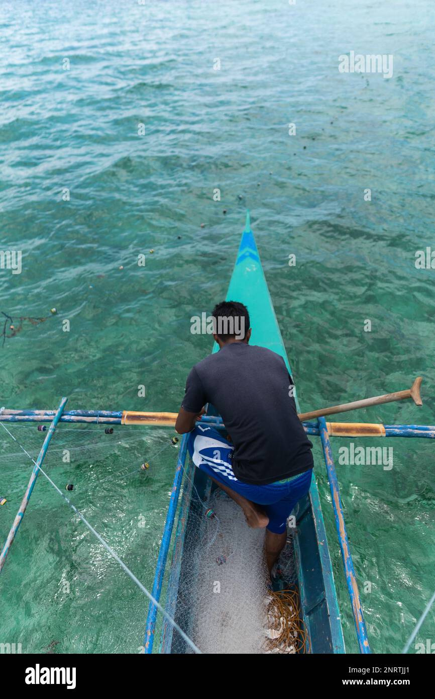 vertical photo of fisherman collecting fishing net, philippines Stock ...