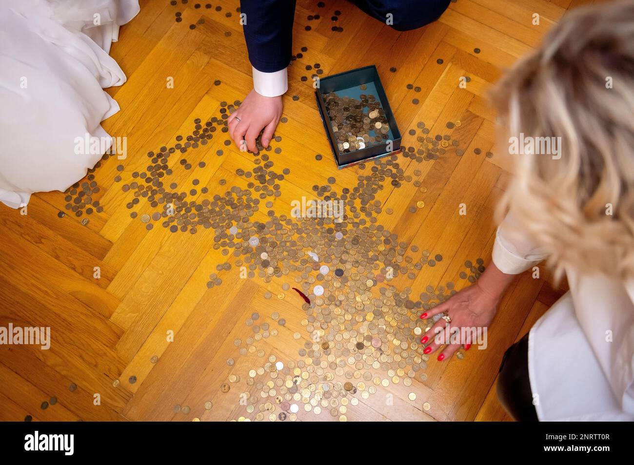 human hands collecting coins scattered on the wooden floor Stock Photo ...