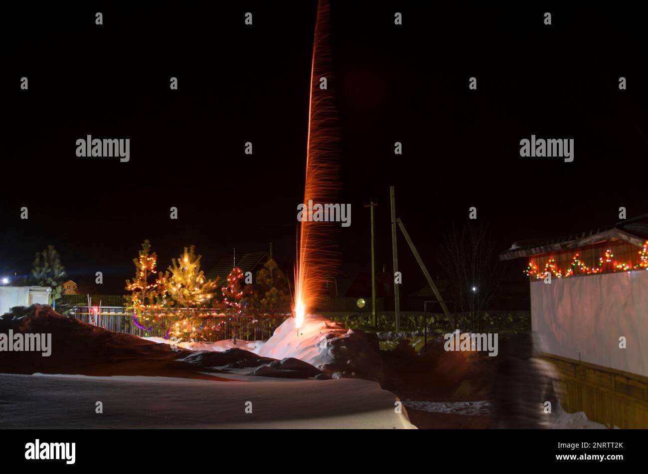 Bright flashes of fireworks in a garden plot in Siberia in winter with ...