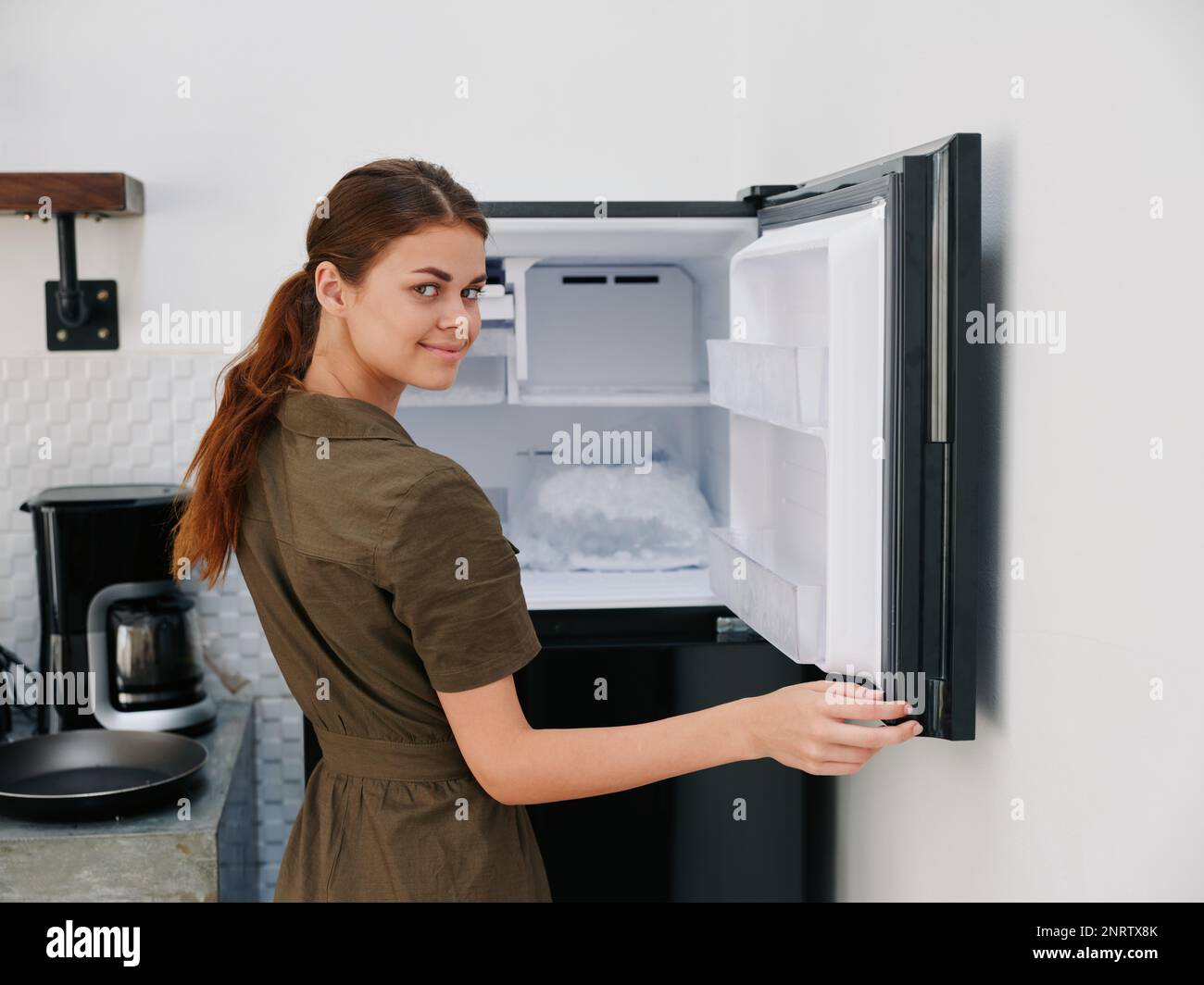 Woman smiling with teeth looking into camera in kitchen at home opened ...