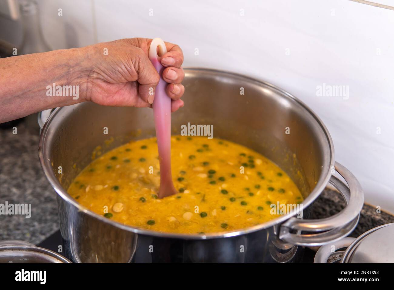 hand of a grandmother mixing the ingredients of the fanesca that is ...