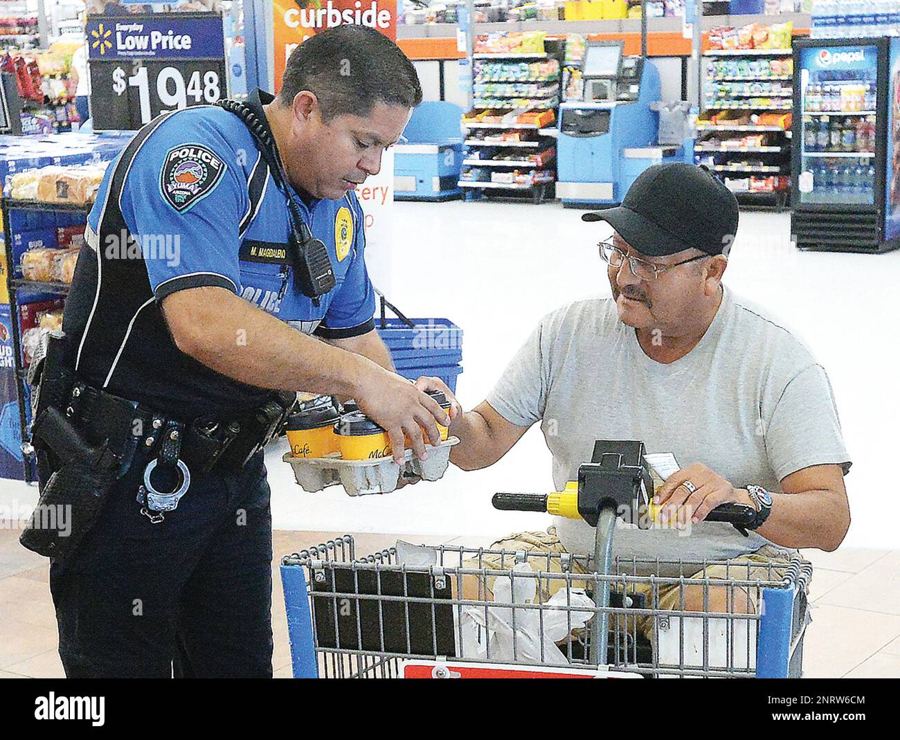 Yuma Police Department officer Martin Magdaleno (left) offers Juan ...