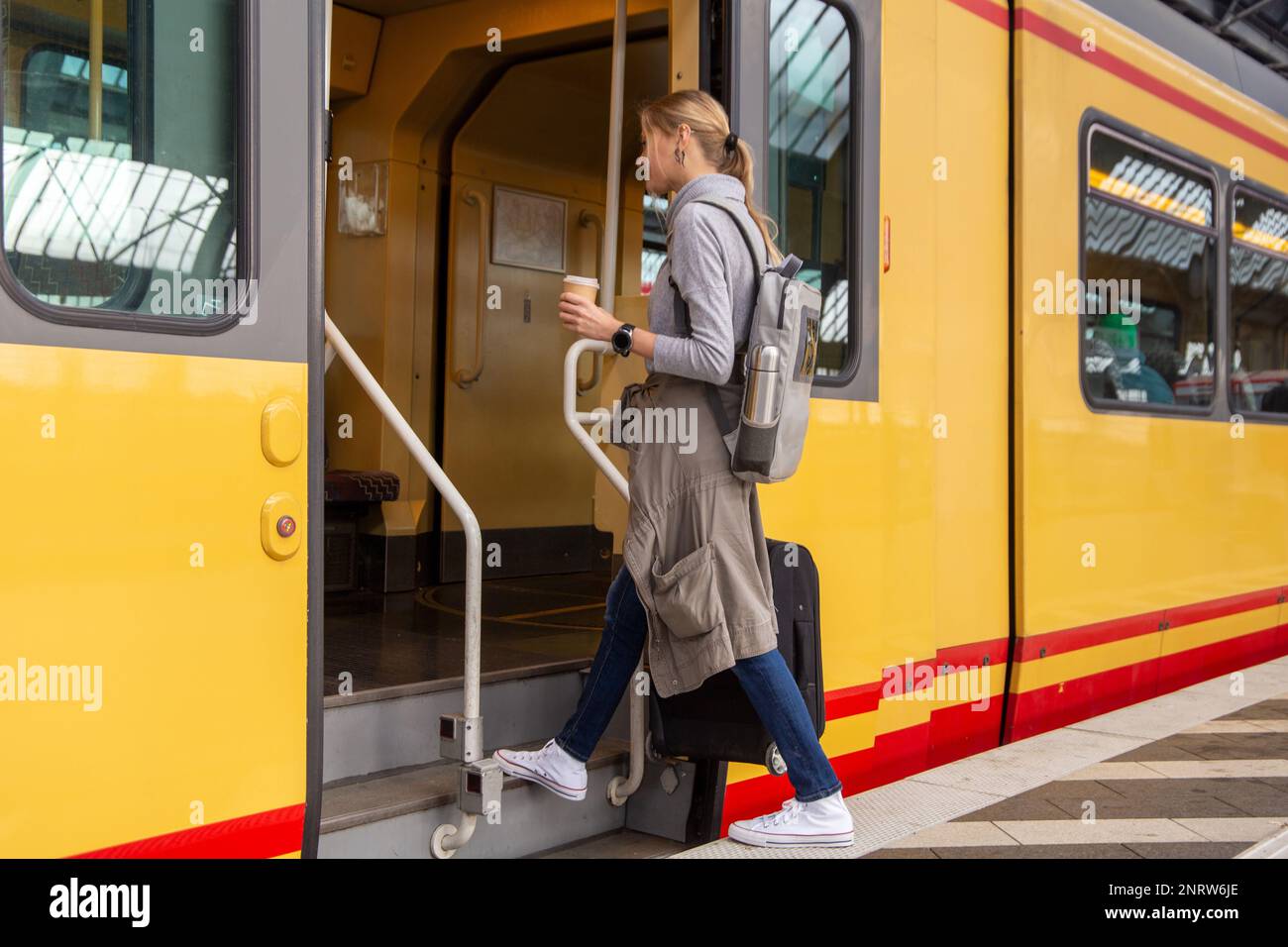 Young woman getting on a train (Model released Stock Photo - Alamy
