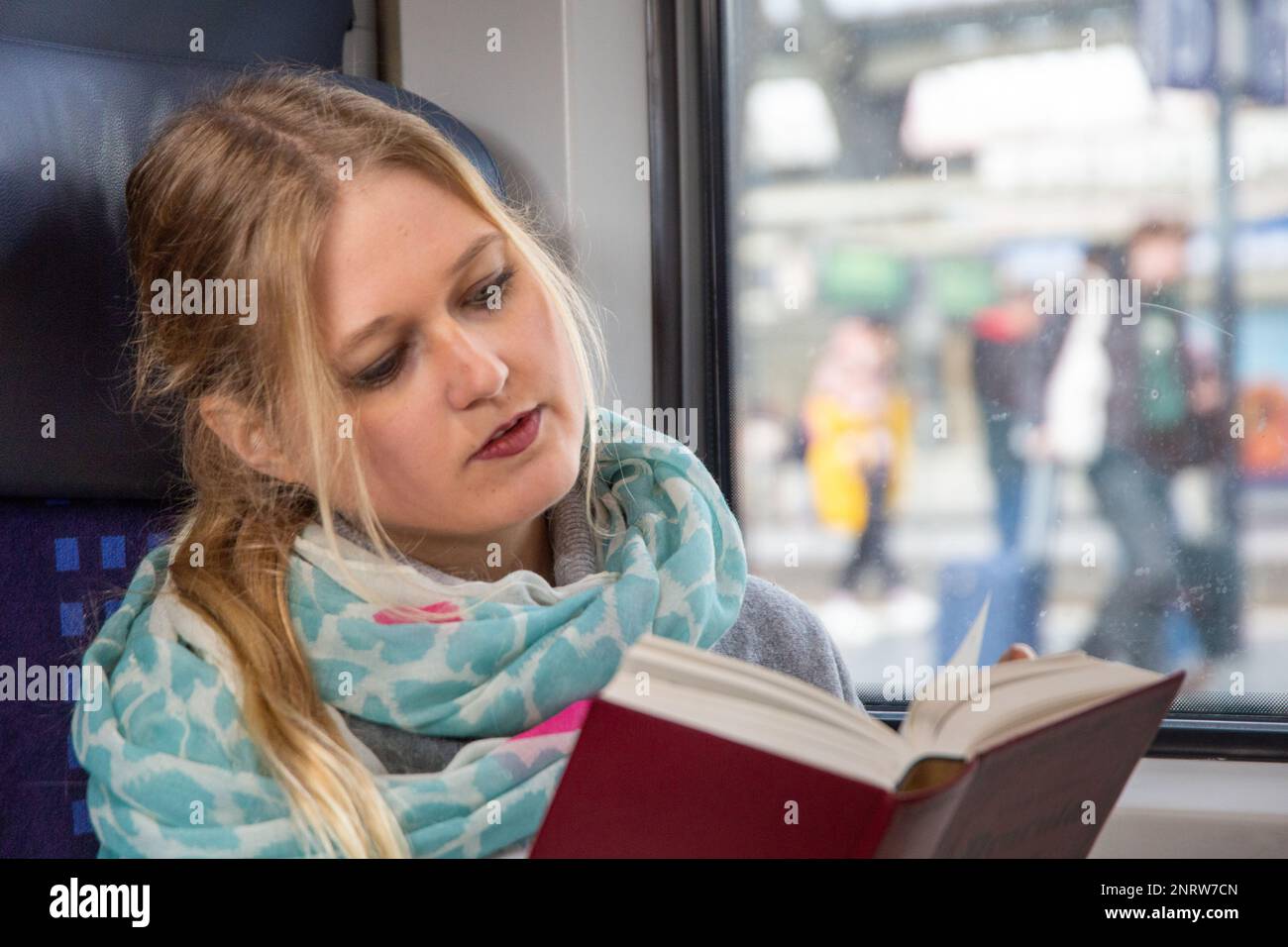 Young woman on train reading a book (Model released Stock Photo - Alamy