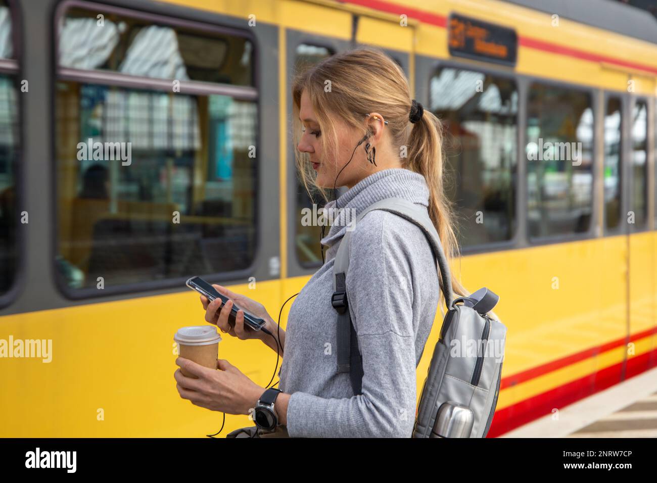 Close-up of a young woman in front of a train in a station (model ...