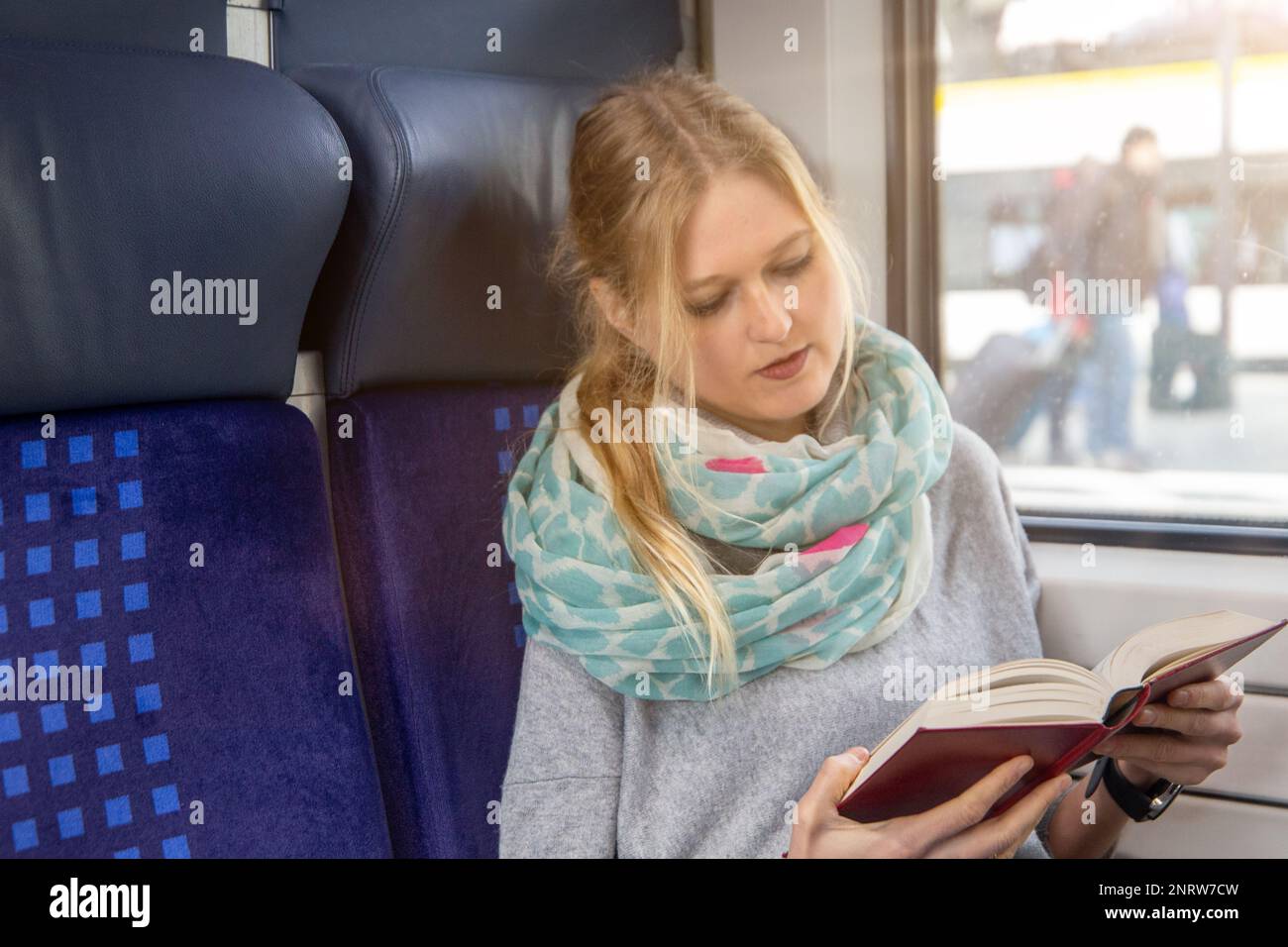 Young woman on train reading a book (Model released Stock Photo - Alamy
