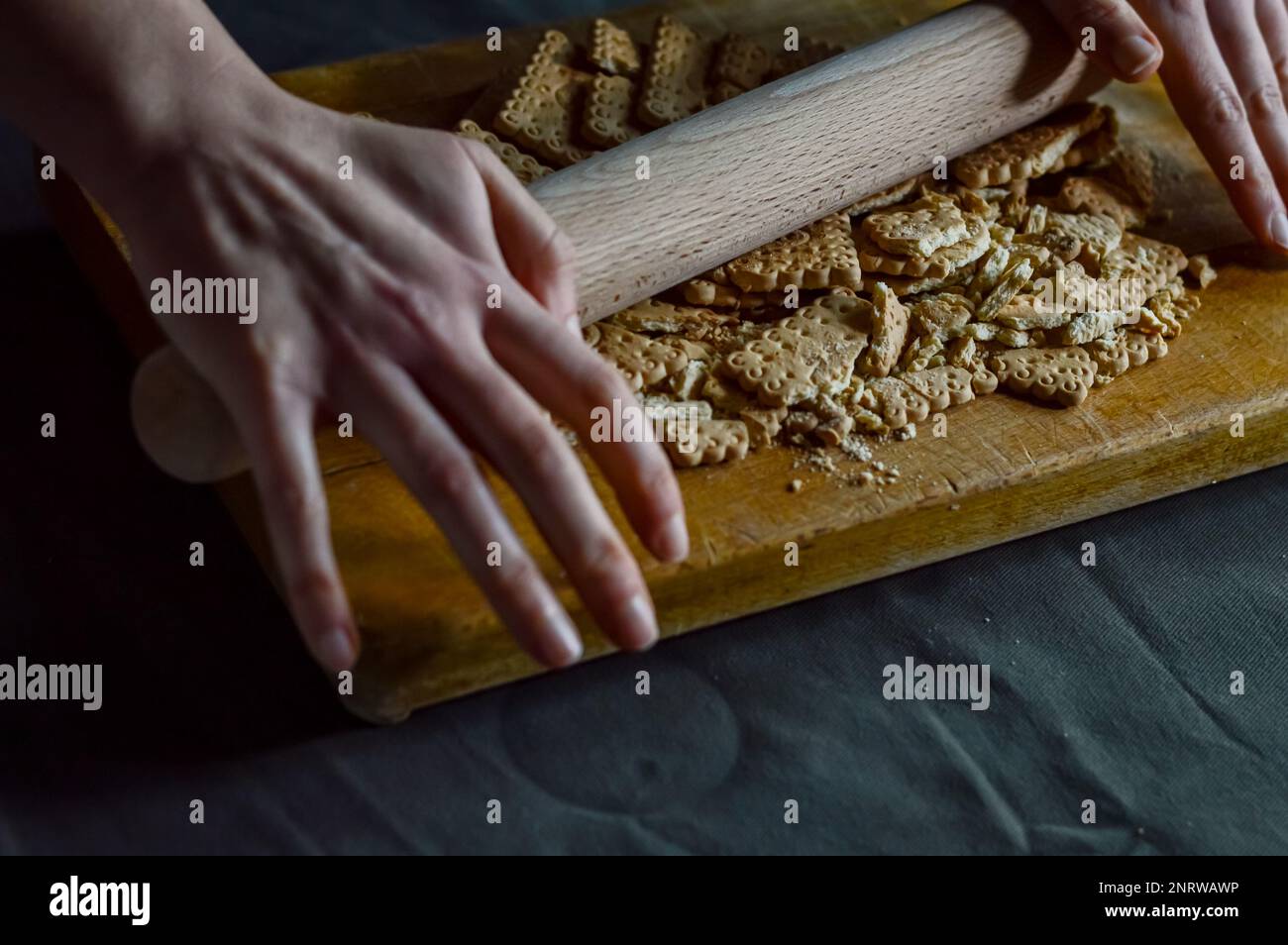 hands that break biscuits with a rolling pin to prepare the crunchy ...