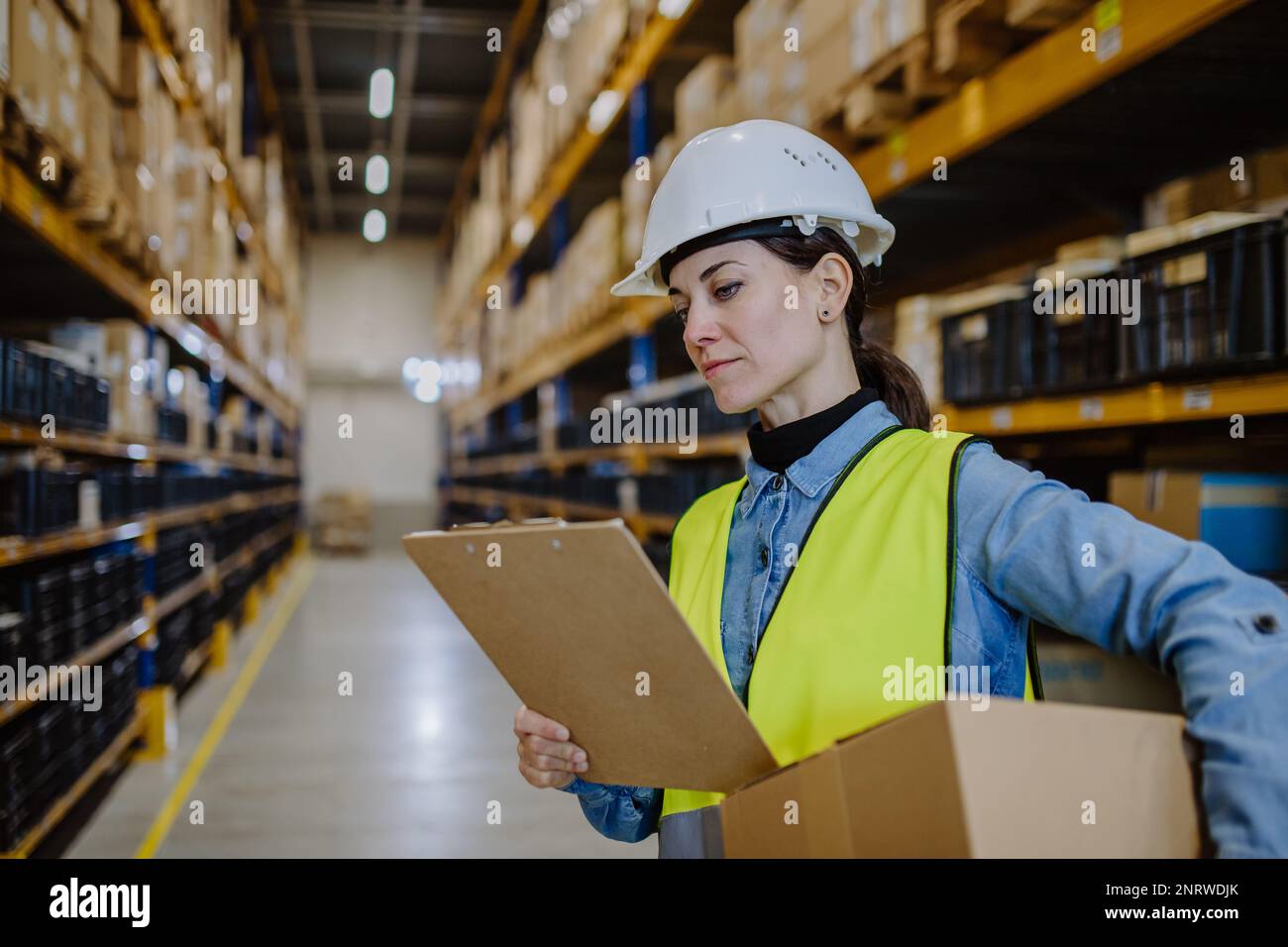 Warehouse female worker checking up stuff in a warehouse Stock Photo ...