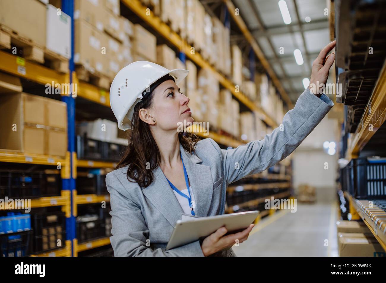 Manager woman in suit controlling goods in a waehouse Stock Photo - Alamy