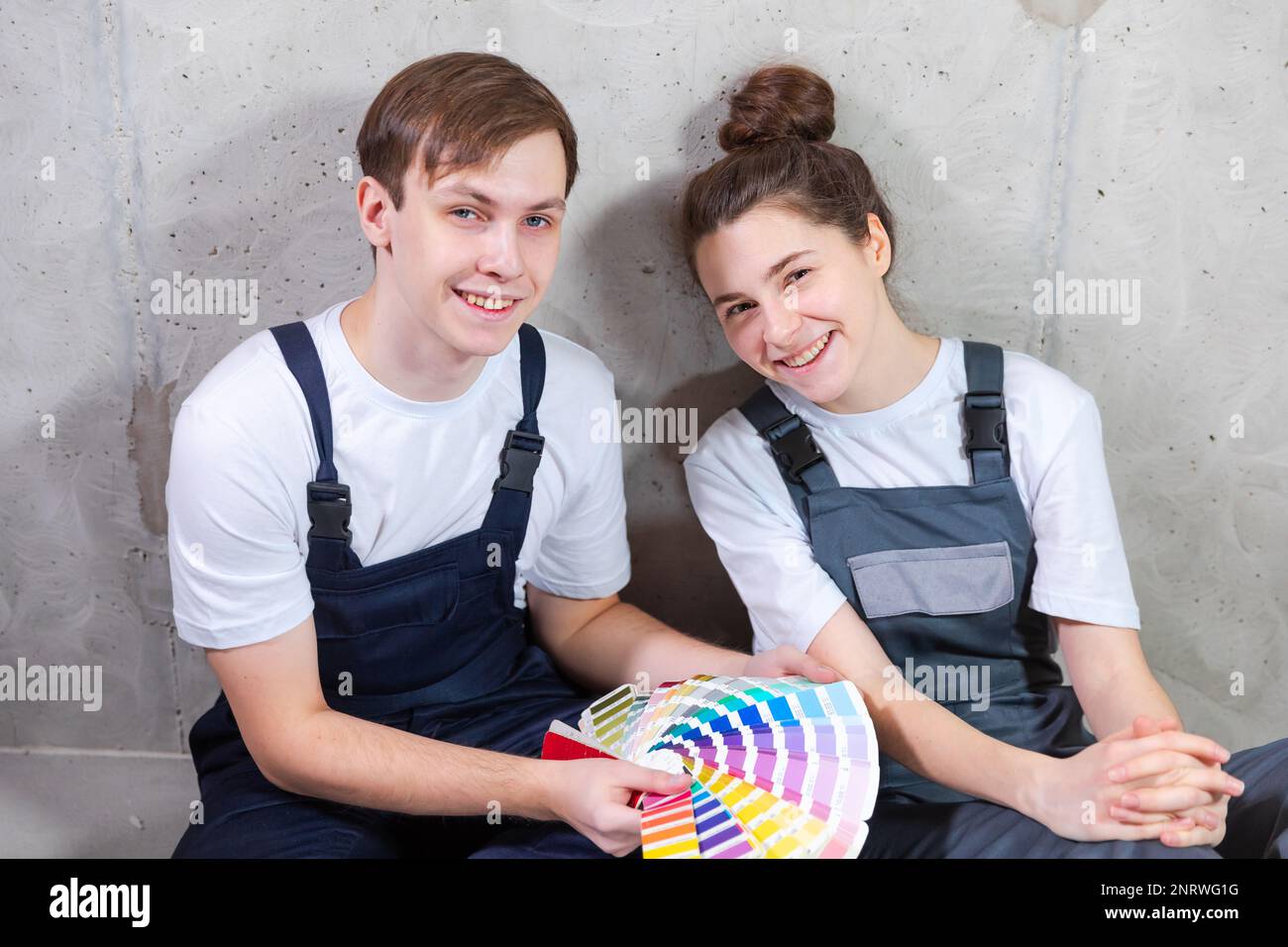 House decoration DIY renovation concept. Happy couple sitting on floor ...
