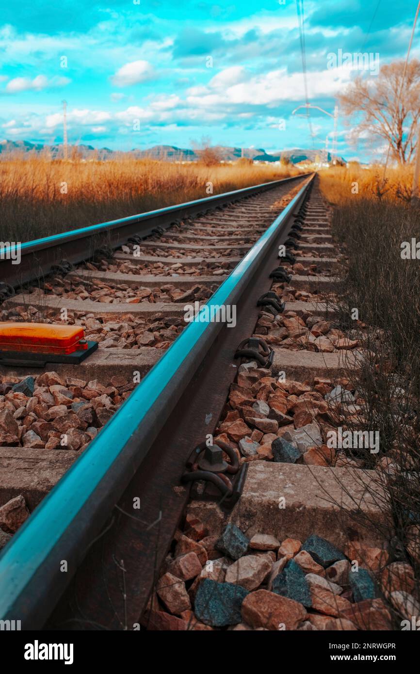 Empty railway in country side against a blue sky with clouds. Concept ...
