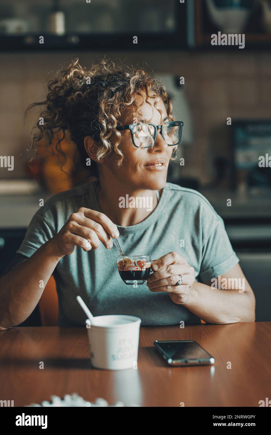 Adult woman drinking italian espresso coffee at home alone sitting in ...