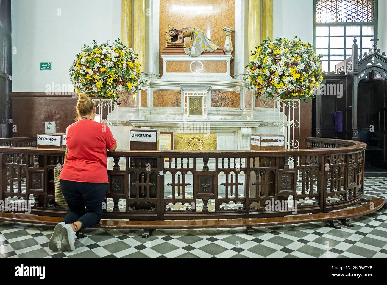 Woman praying with the cellphone, in Basilica of Our Lady of Candelaria ...