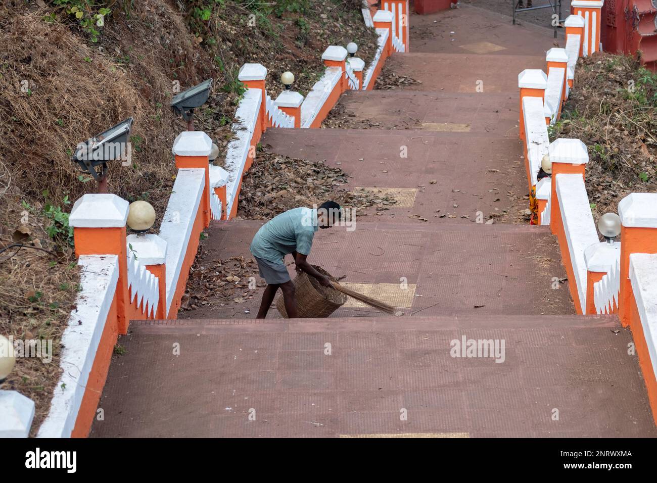 Panjim, Goa, India - January 2023: An Indian man sweeping a street with ...