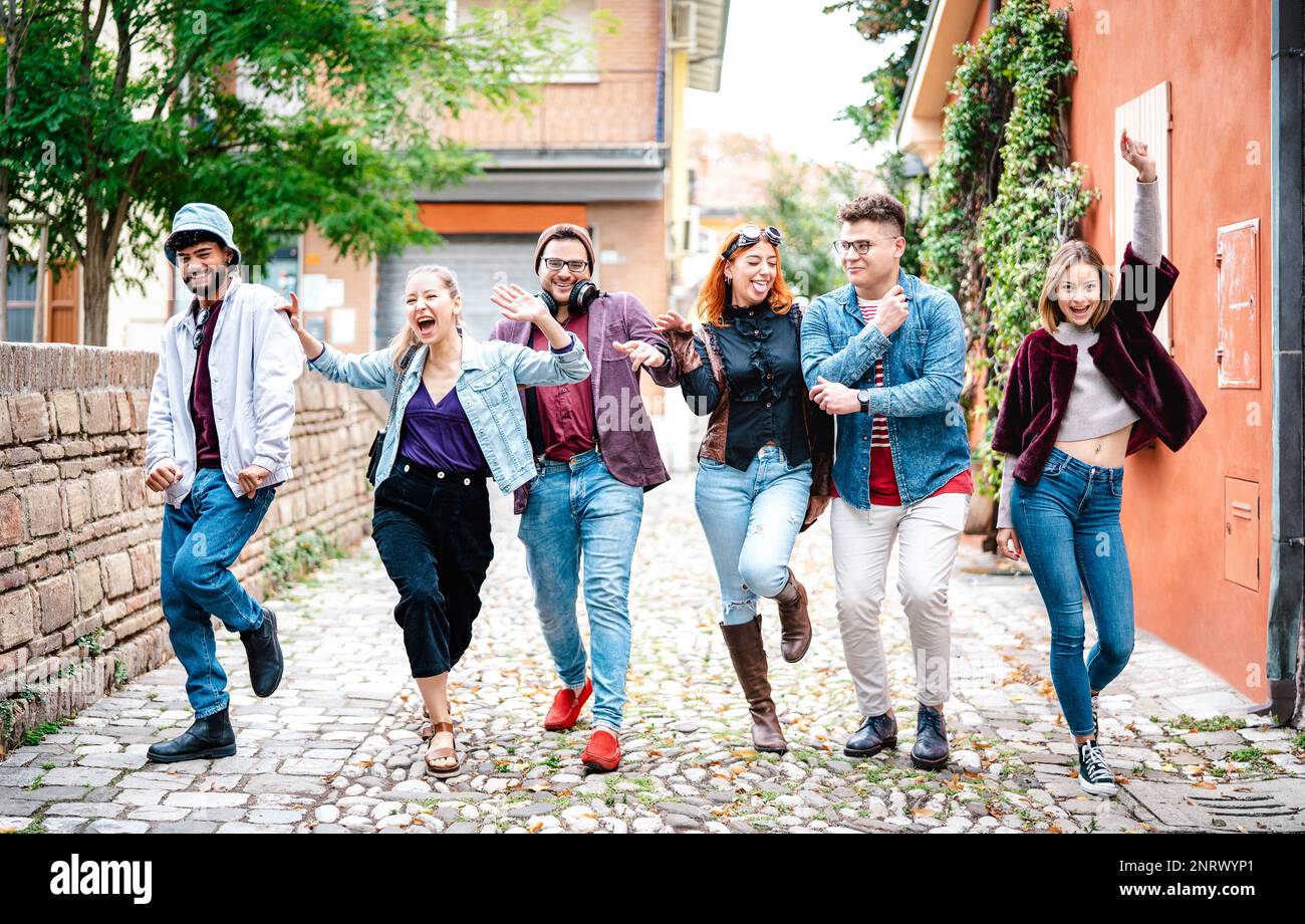 Cool trendy urban friends walking at old town acting crazy funny moves ...