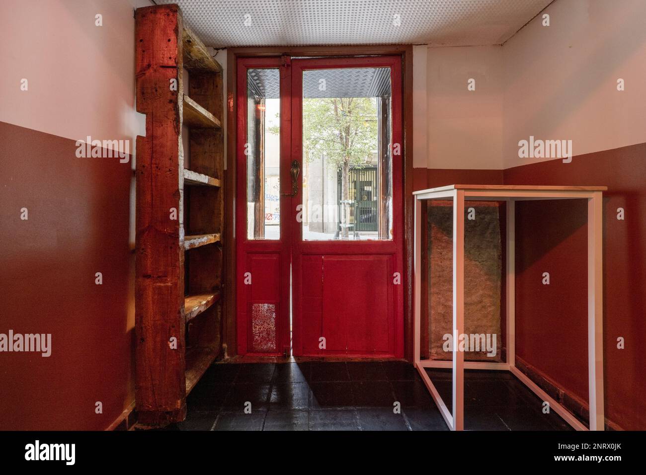 Access door of an empty local at street level with wooden bookshelf and ...