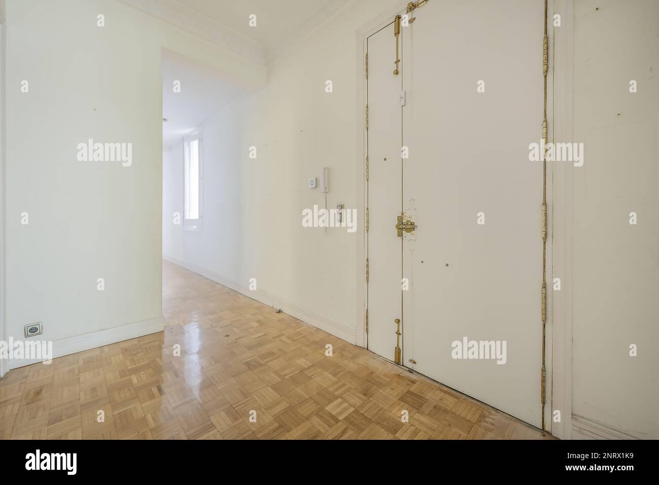 Entrance hall of a house with a white access door with golden safety ...