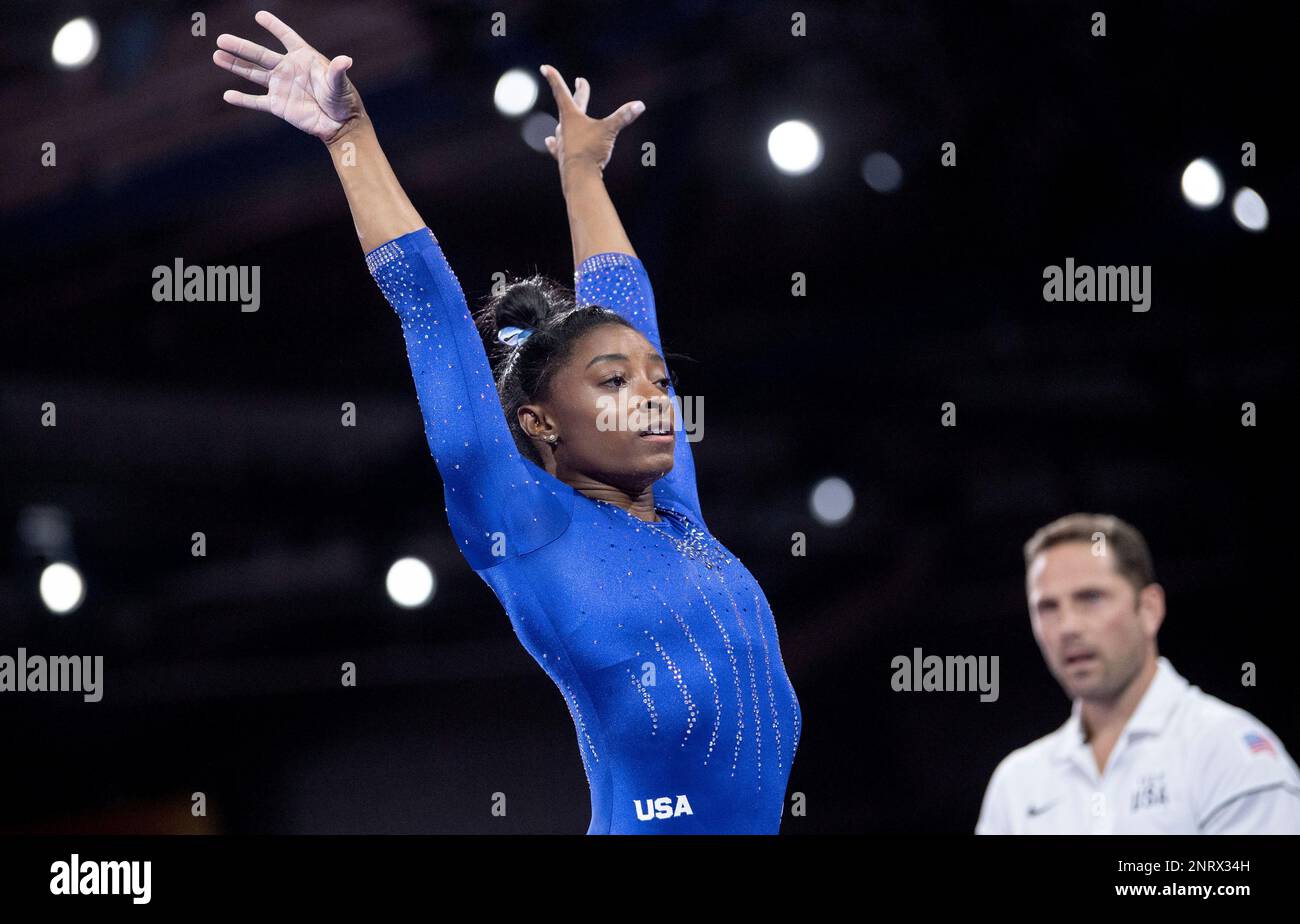 Simone Biles, of the United States, raises her arms after landing while ...