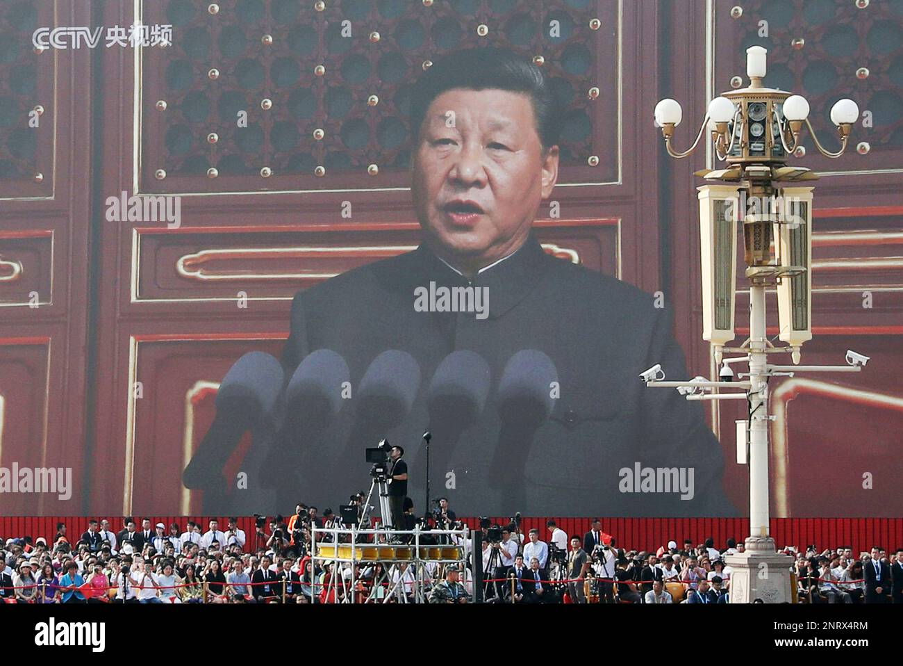 A monitor shows China's President Xi Jinping attending a military ...