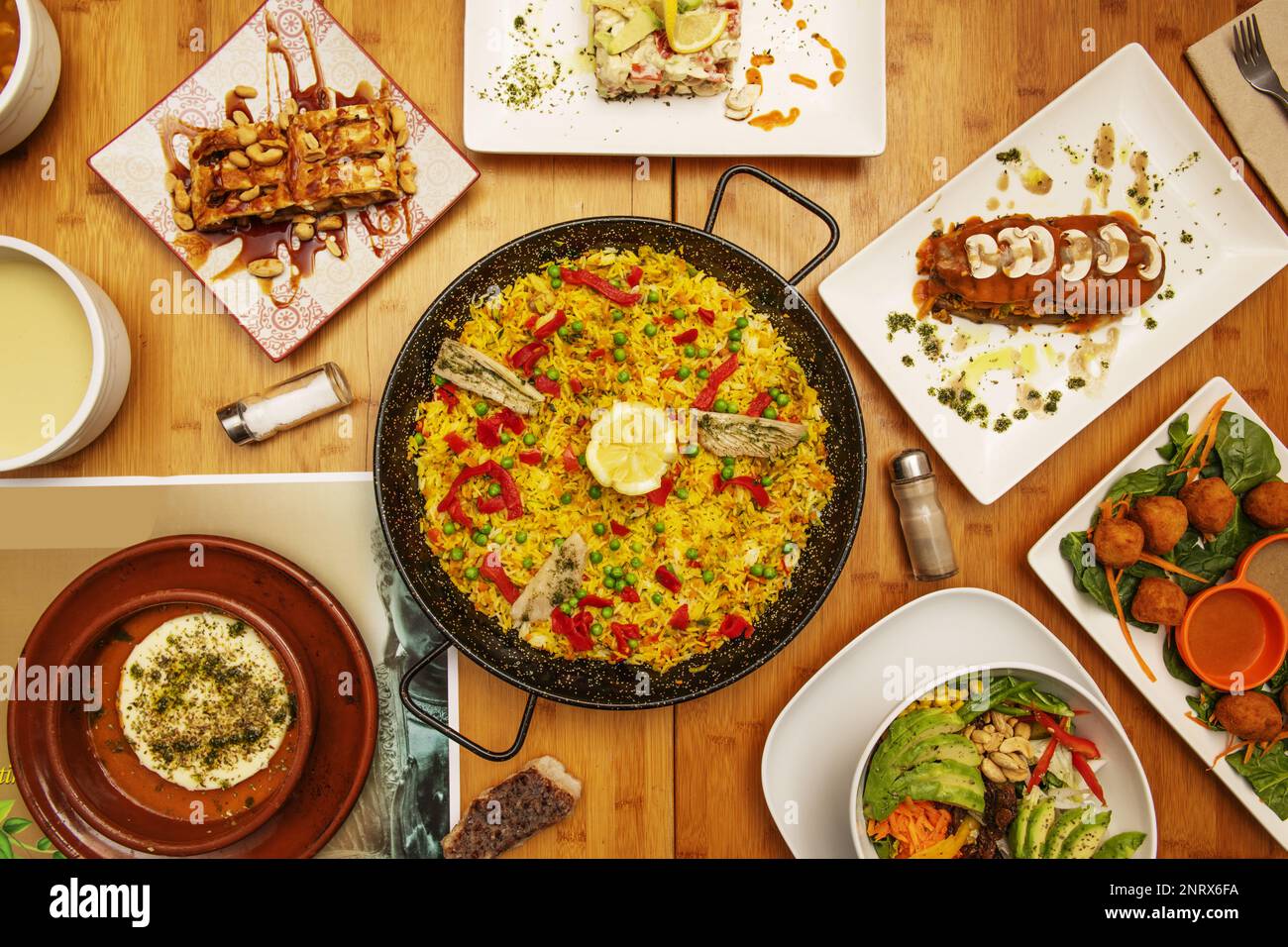 Spanish tapas recipes with a fish paella in the center, healthy salads ...