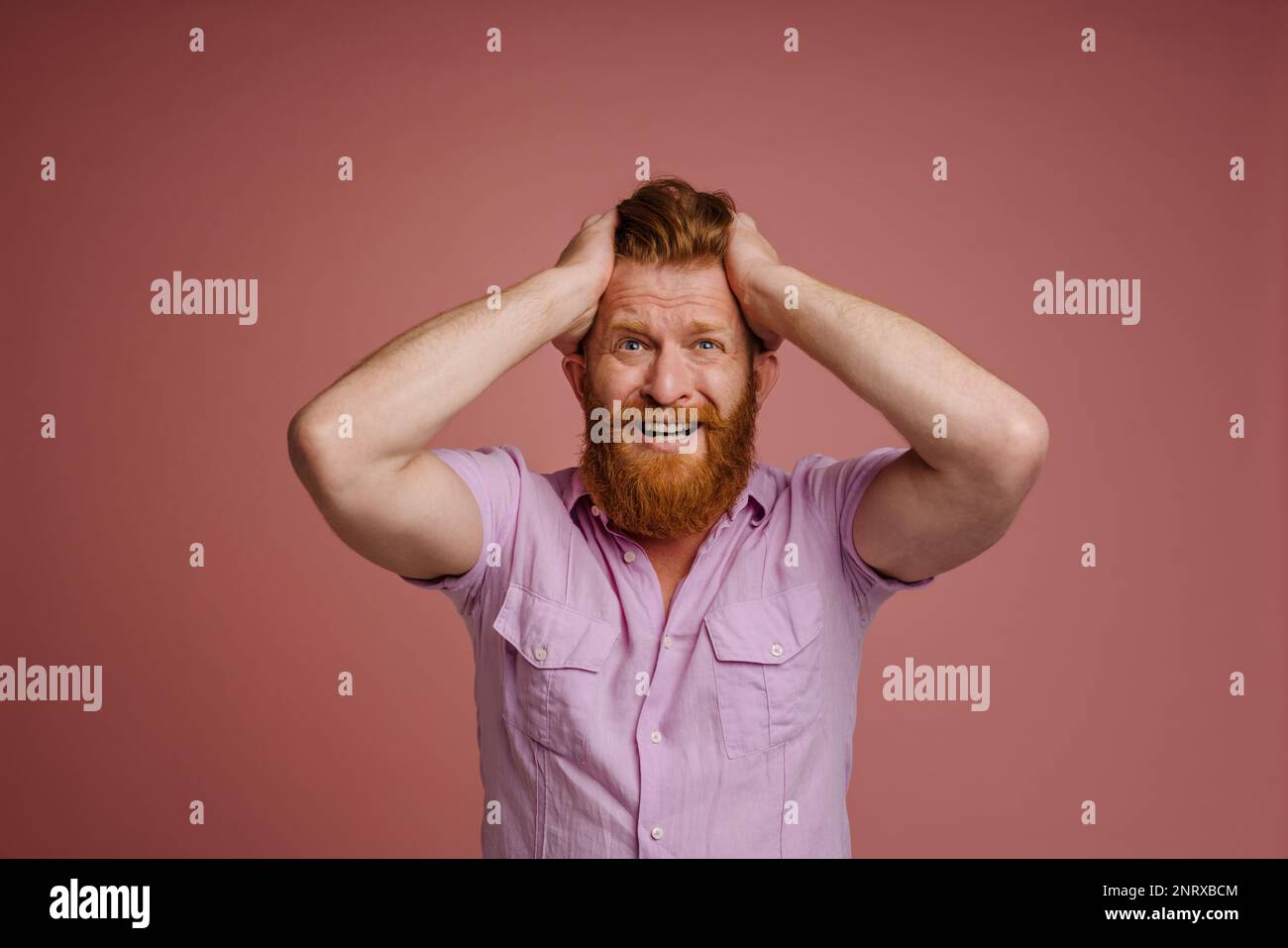 Ginger scared man holding his head and screaming at camera isolated ...