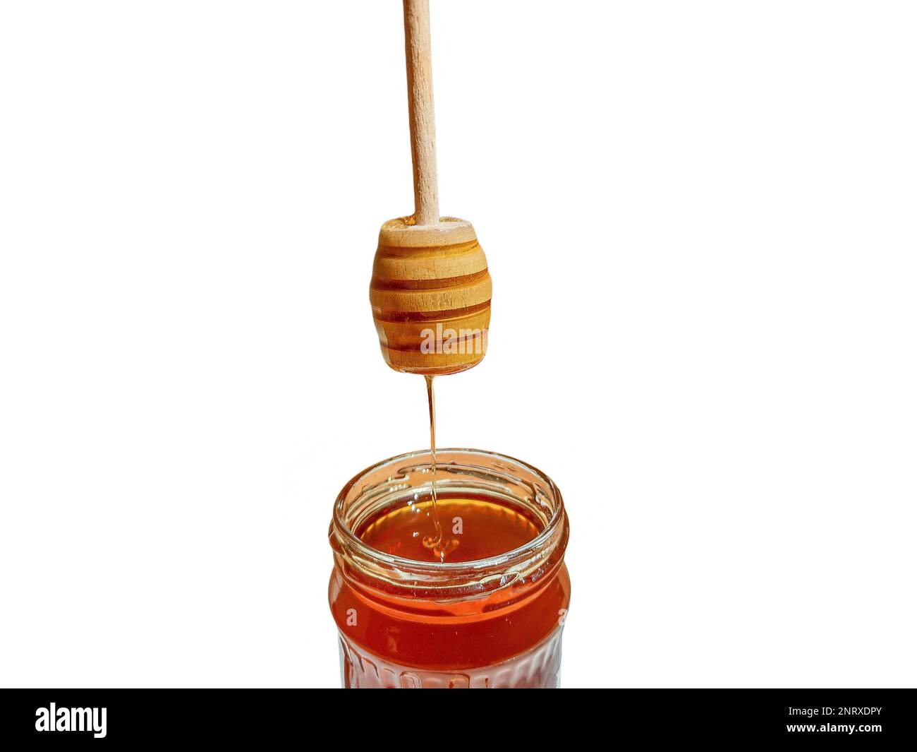 polyflora bee honey flowing into a jar from a wooden spoon. The concept ...