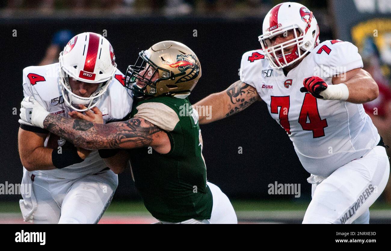 Western Kentucky quarterback Ty Storey (4) is hit by UAB defensive ...