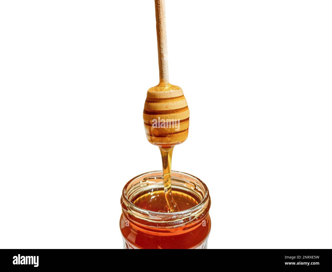 polyflora bee honey flowing into a jar from a wooden spoon. The concept ...