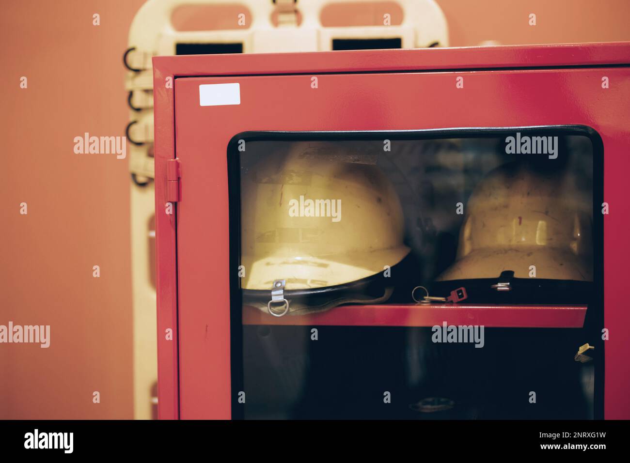 Firefighter suits and helmets hanging in a locker room at fire station ...