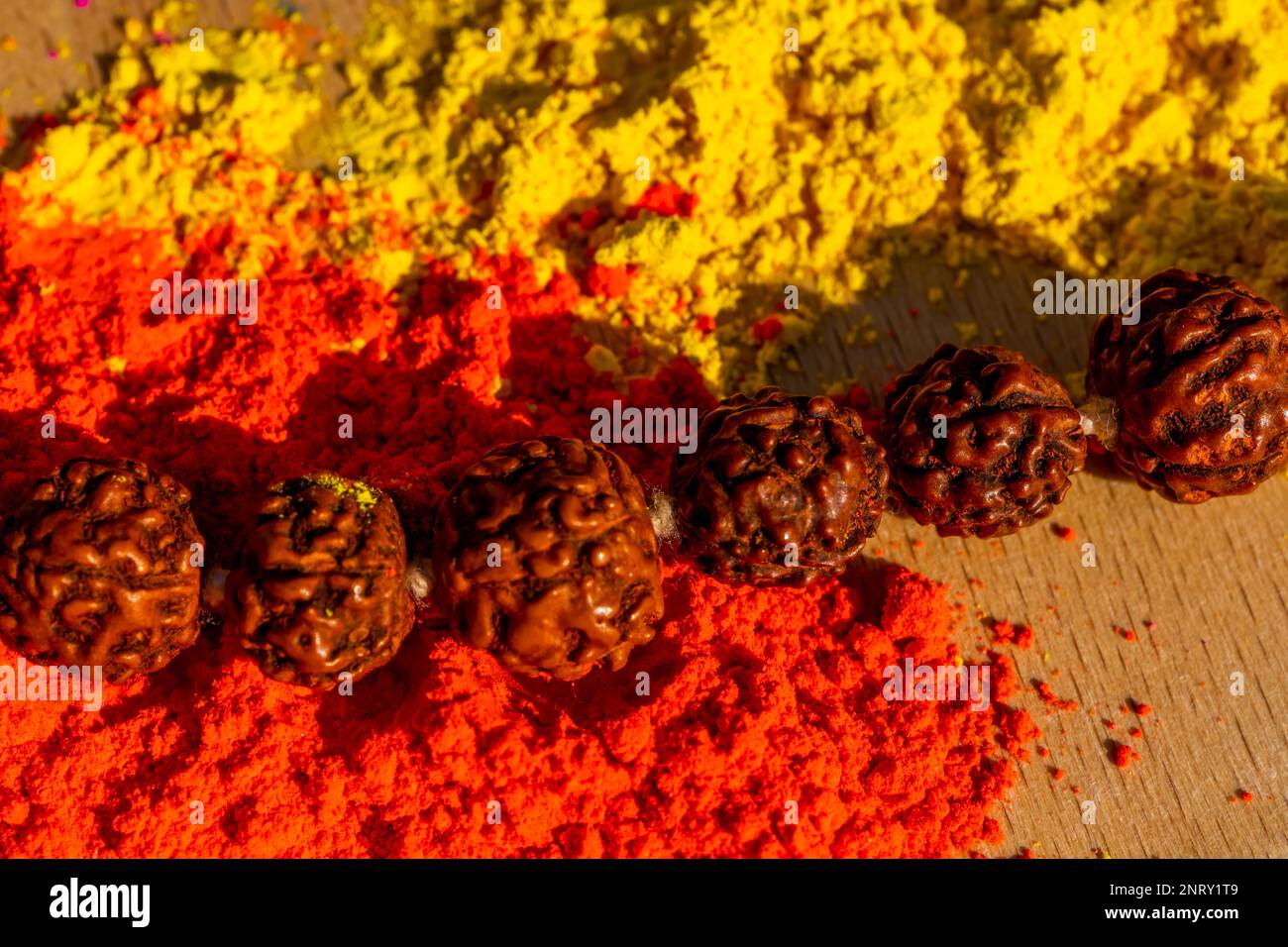 Colorful traditional holi powder on the table with wooden prayers ...