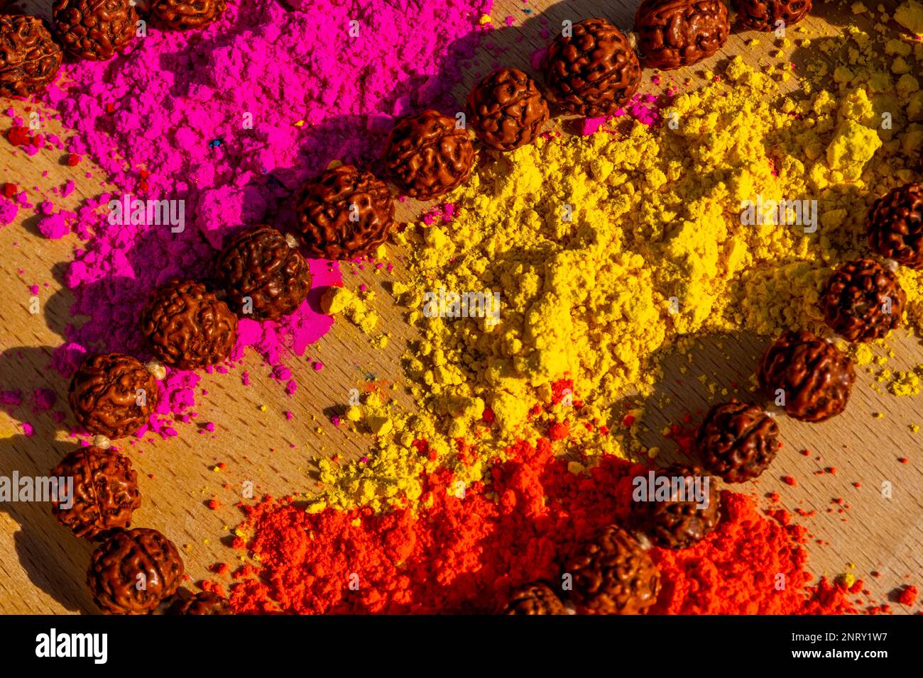 Colorful traditional holi powder on the table with wooden prayers ...