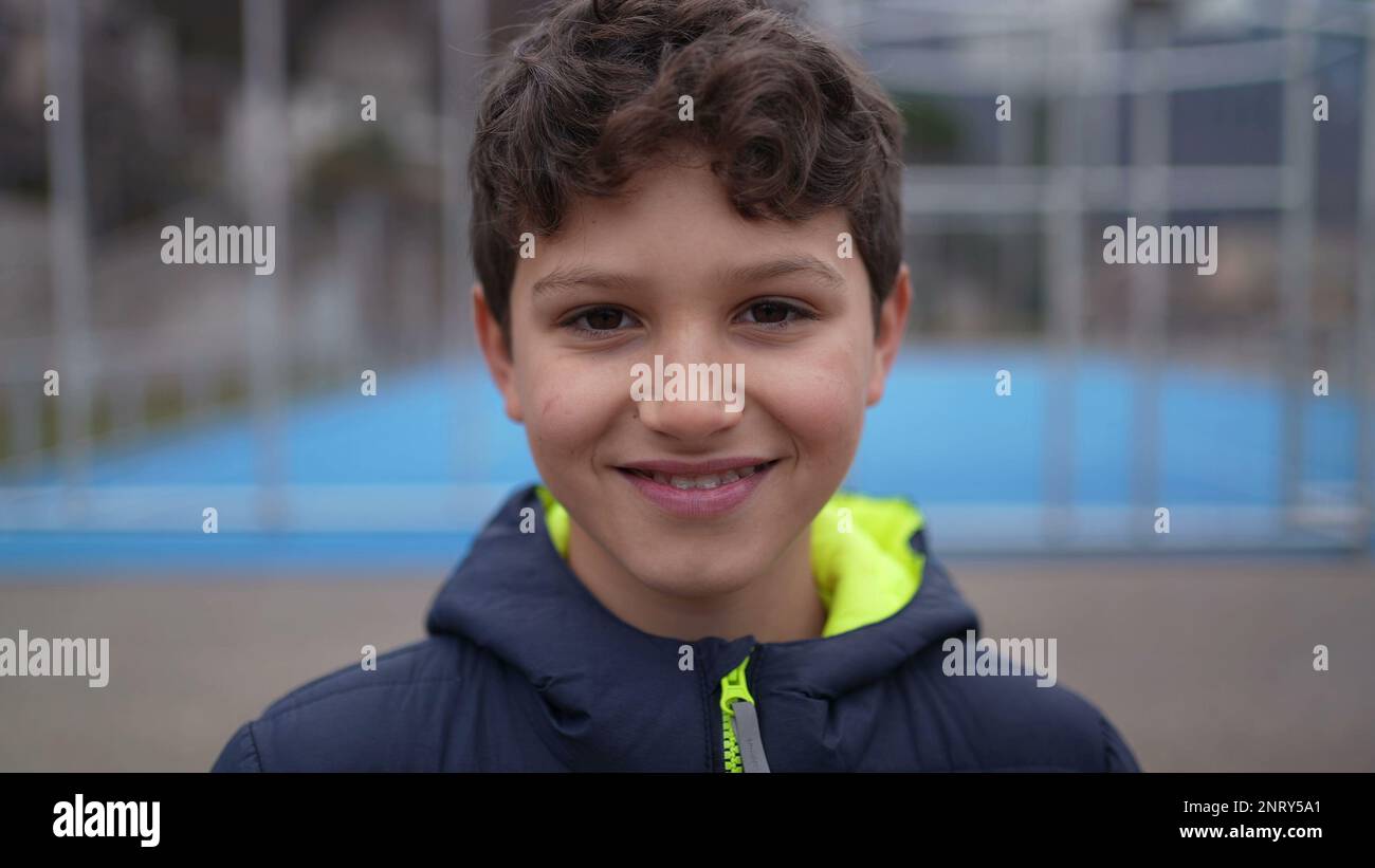 Portrait of a happy handsome young boy standing outside. Closeup face ...