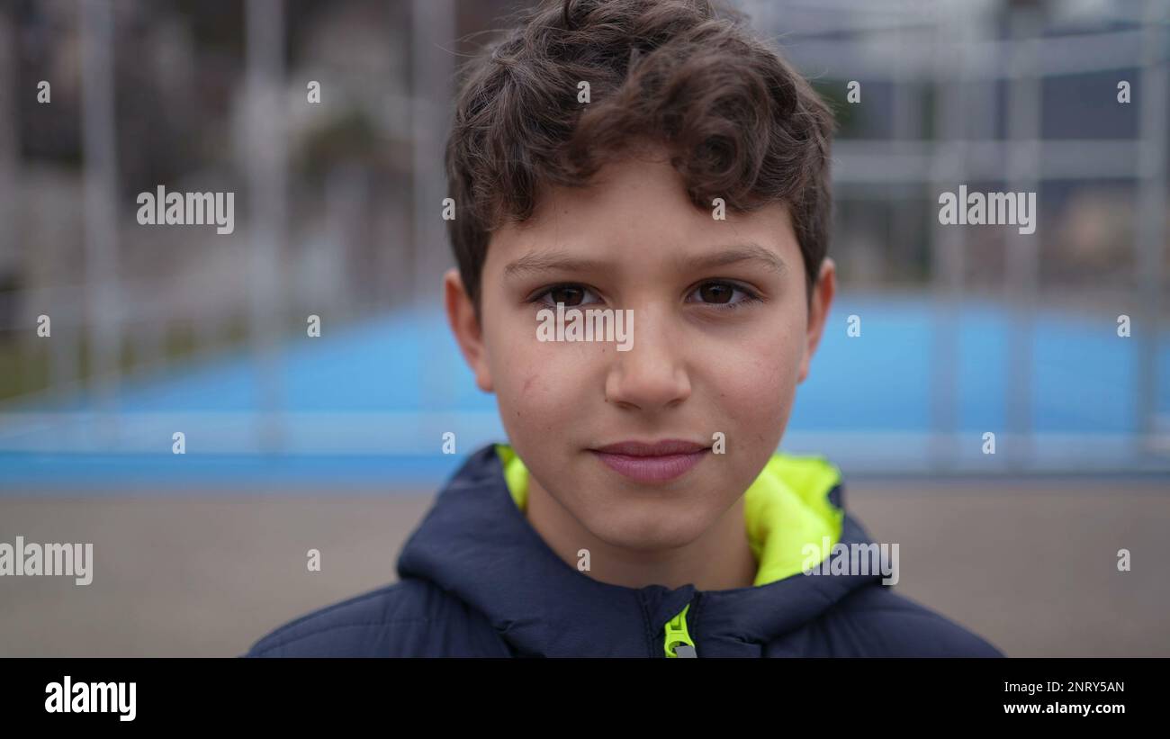 Portrait of a happy handsome young boy standing outside. Closeup face ...