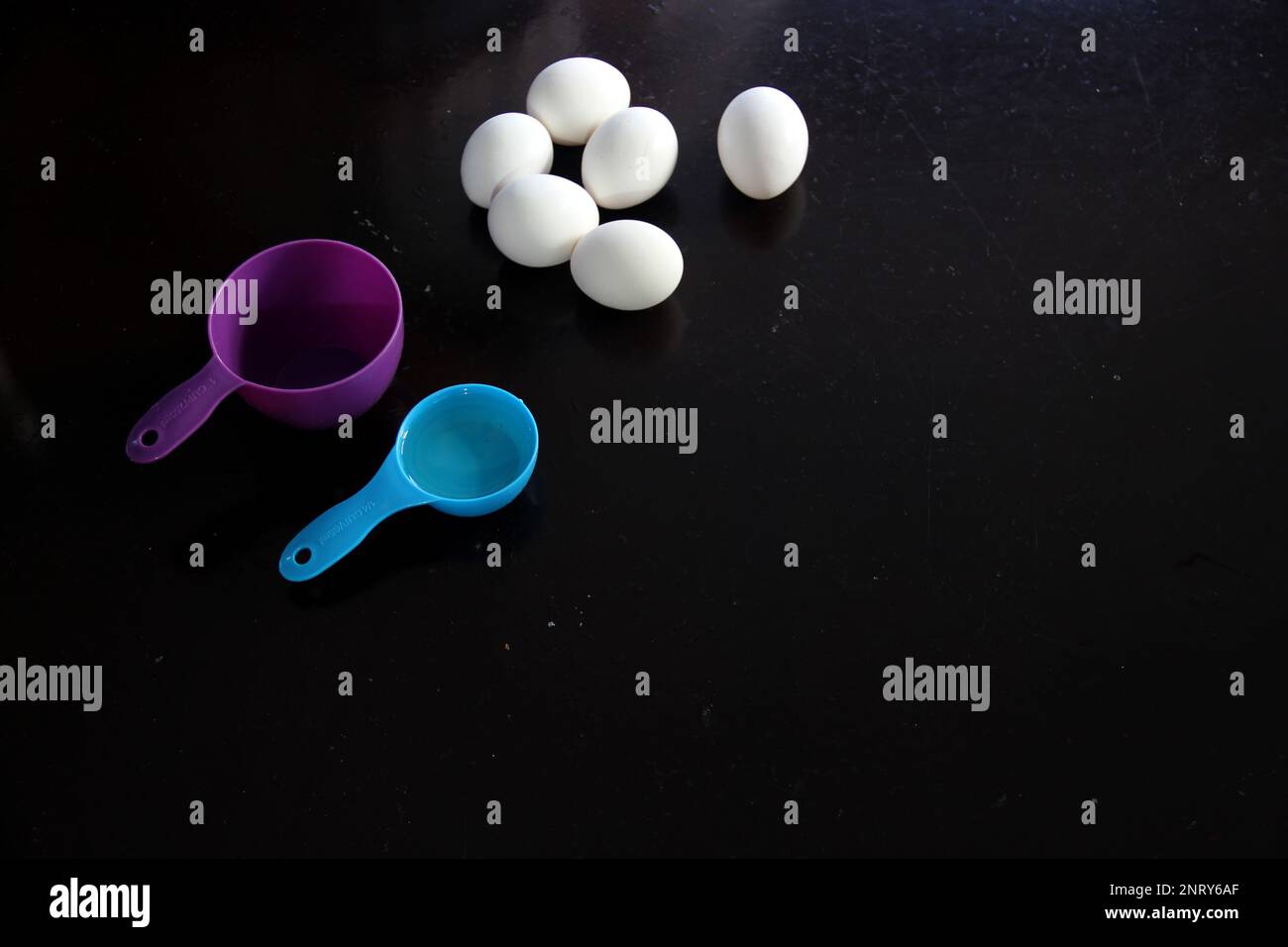 Kitchen utensils for measuring and eggs on black table background Stock ...