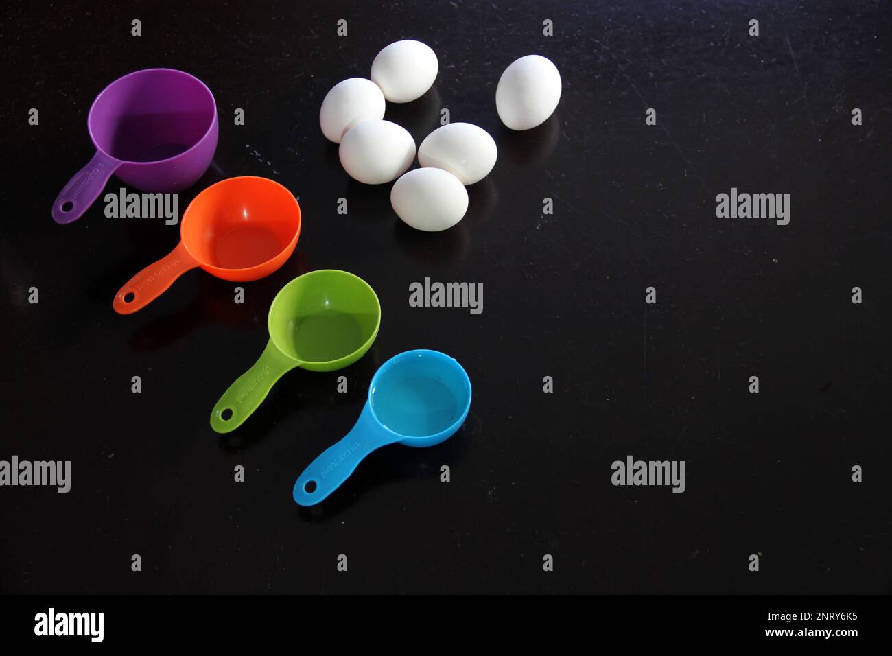 Kitchen utensils for measuring and eggs on black table background Stock ...