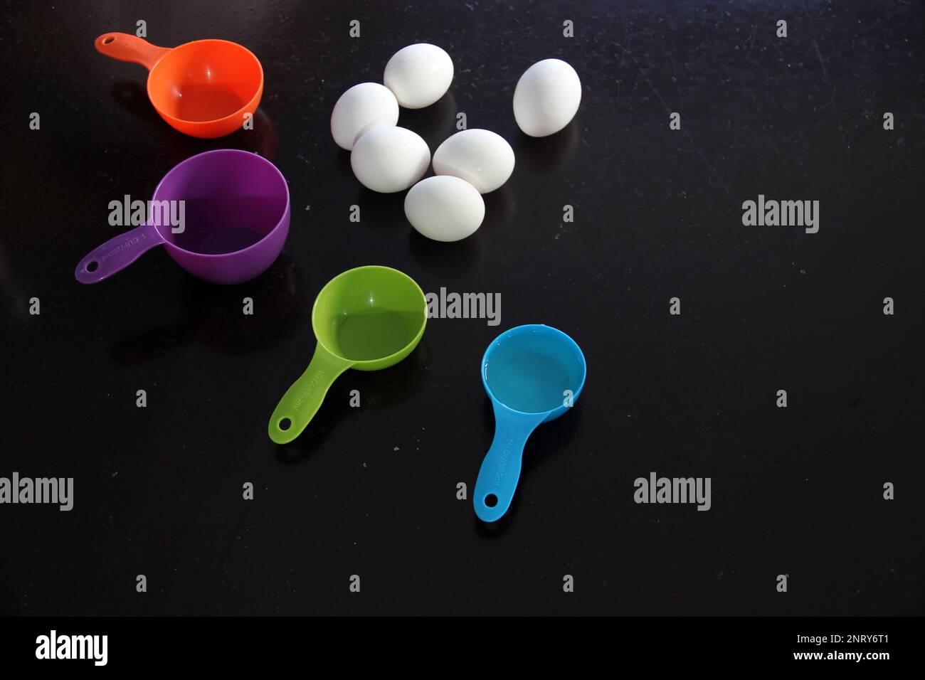 Kitchen utensils for measuring and eggs on black table background Stock ...
