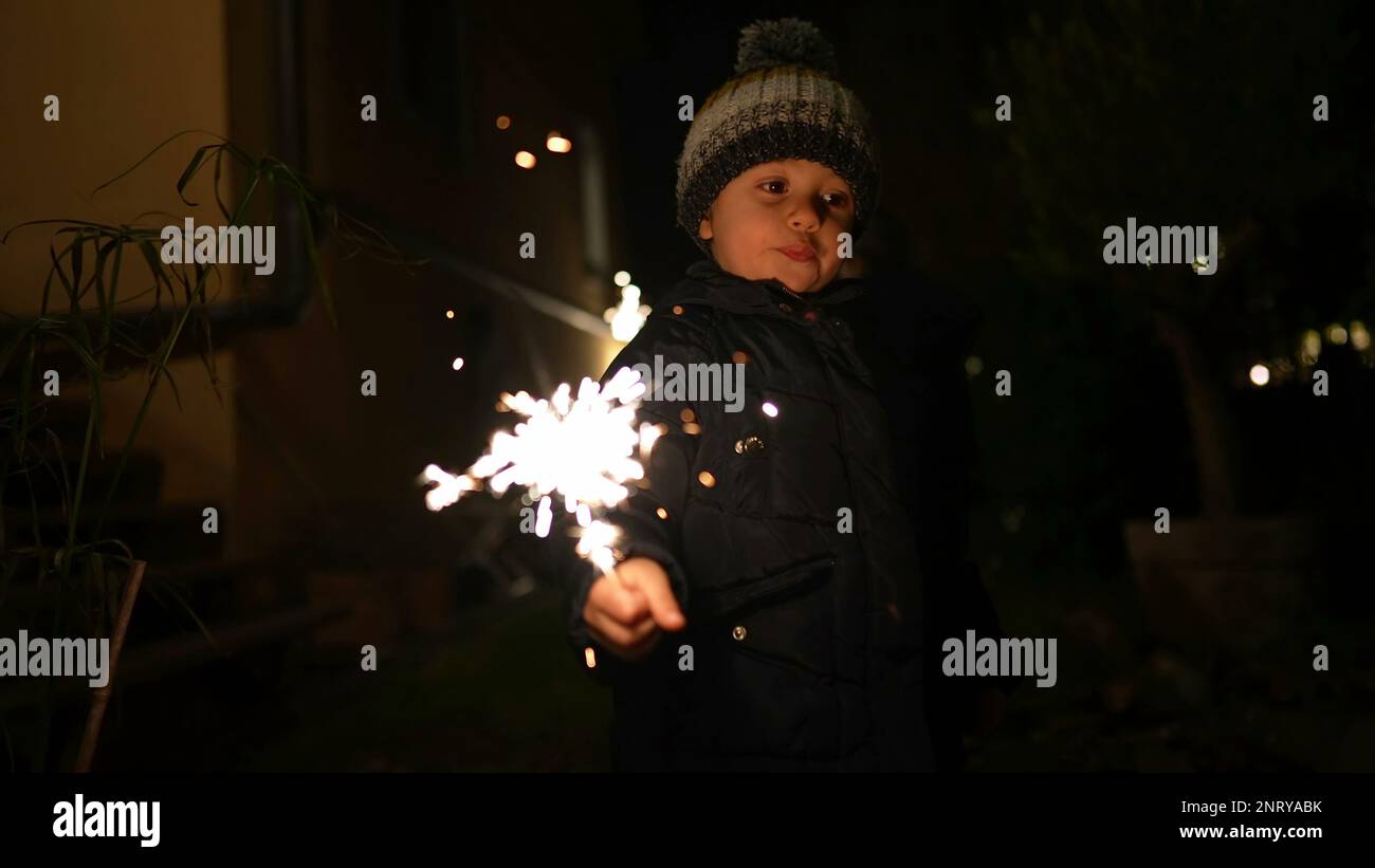 One young boy holding sparkler at night. Happy child celebrating ...
