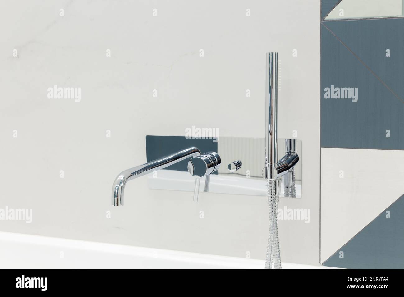 Ultra modern bathroom in stark white with silver faucet. A bathtub in a ...