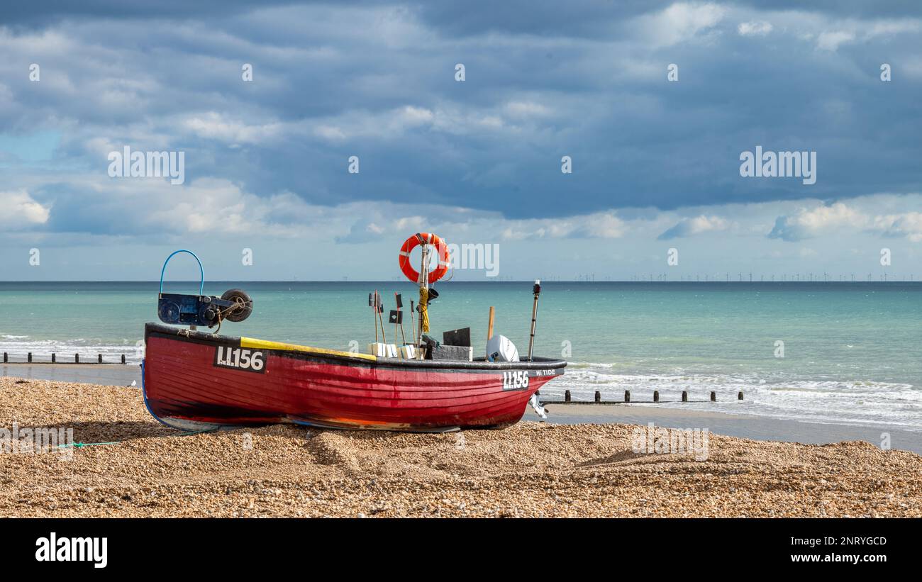 A traditional wooden fishing boat pulled up on the beach at Bognor ...