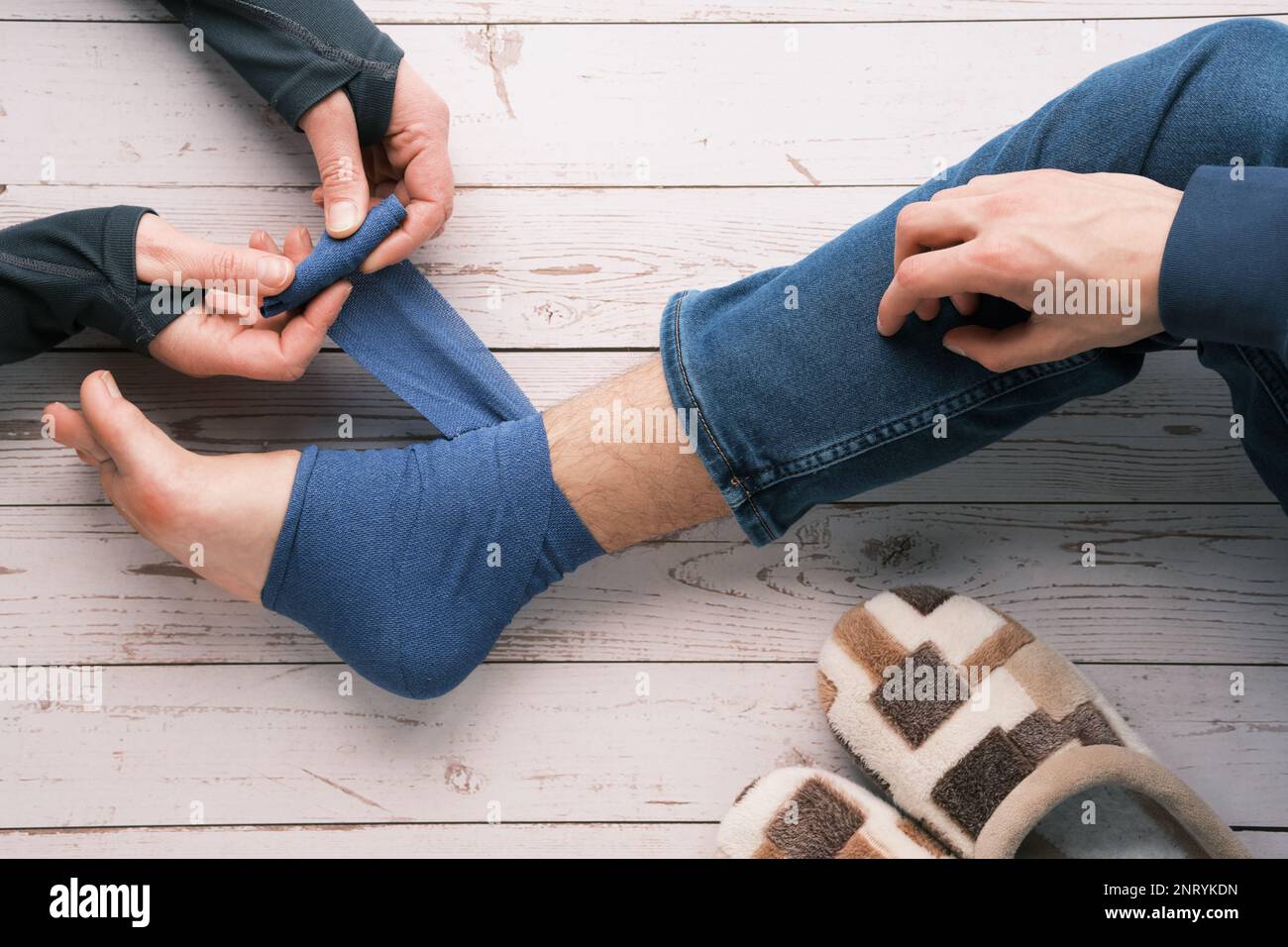 Feet trauma, injury. Adult wrapping compression bandage around sprained ...
