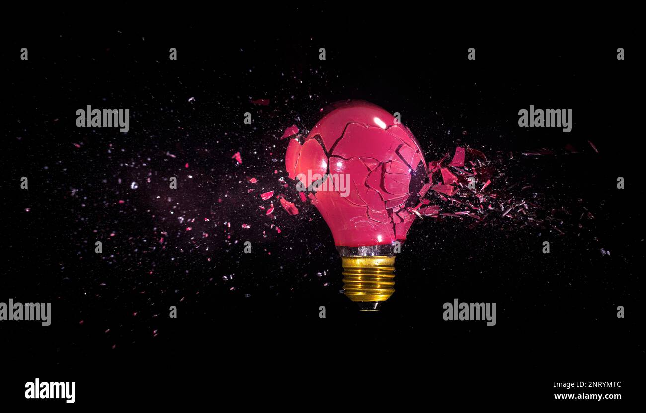breaking of a red bulb on a black background. high speed photography ...