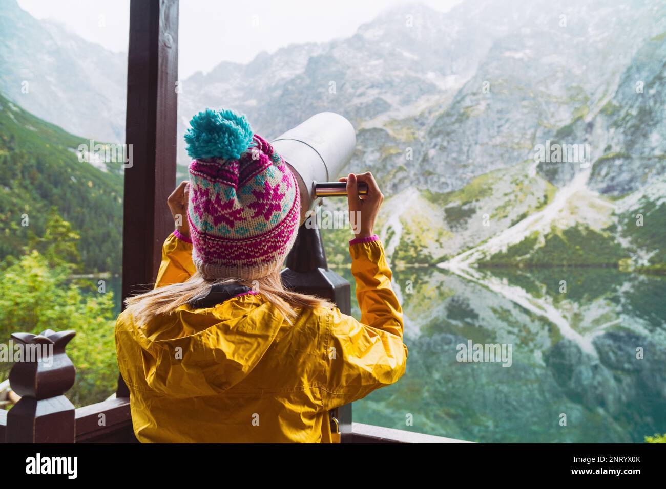 Young blond hair woman wearing yellow jacket, purple and blue cap ...