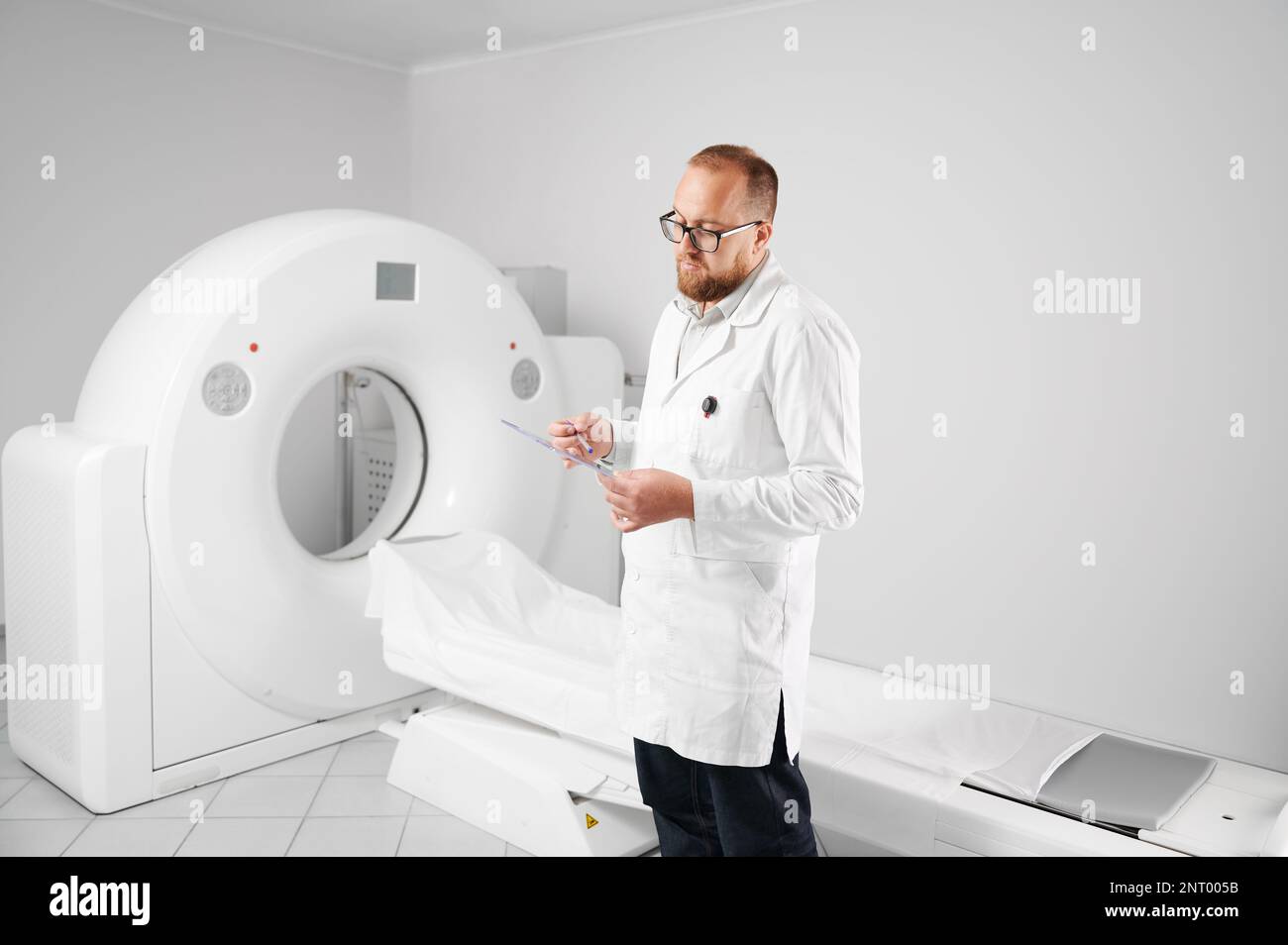 Portrait of doctor with medical computed tomography or MRI scanner ...