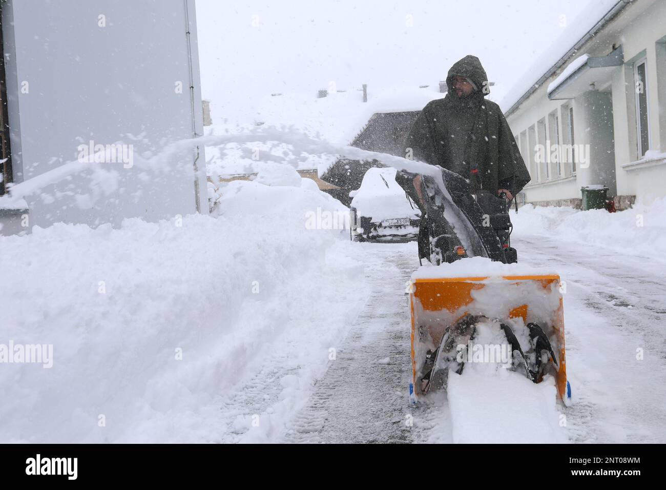Gospic, Croatia, on February 27, 2023. Man clears snow on street ...