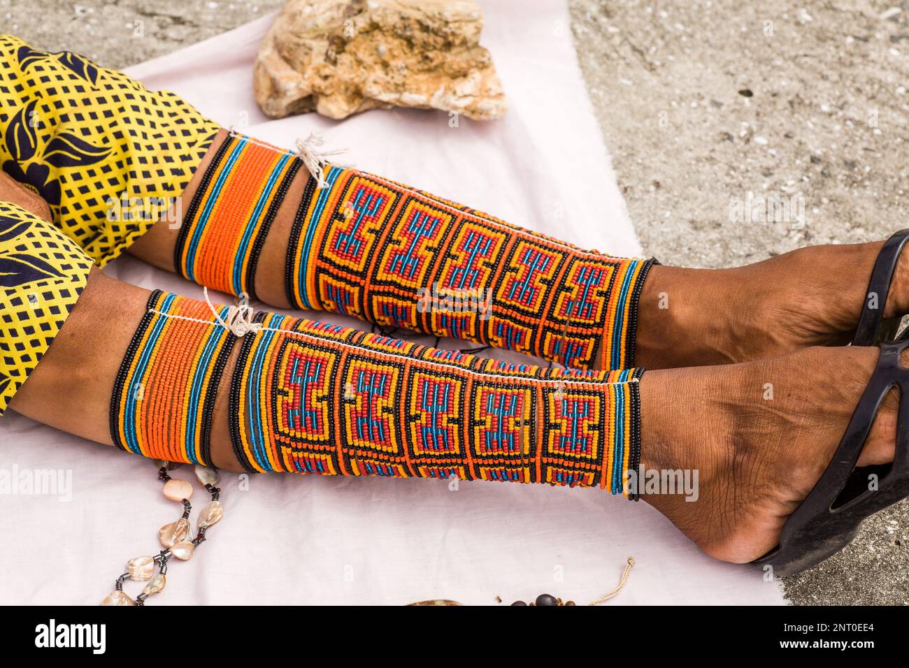 Long single strands of beads wrapped around the arms and legs of the ...